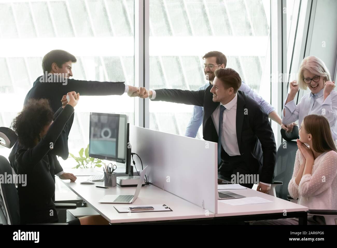 Euphoric mature and young coworkers excited by profitable deal ...