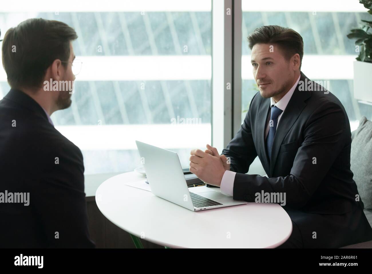Confident male hr manager holding interview with young job seeker Stock ...