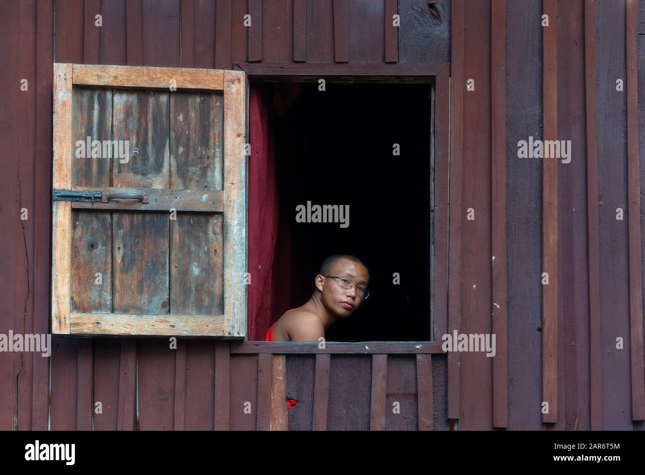 Nyaungshwe, Myanmar - December 26, 2019: A young monk looking out ...