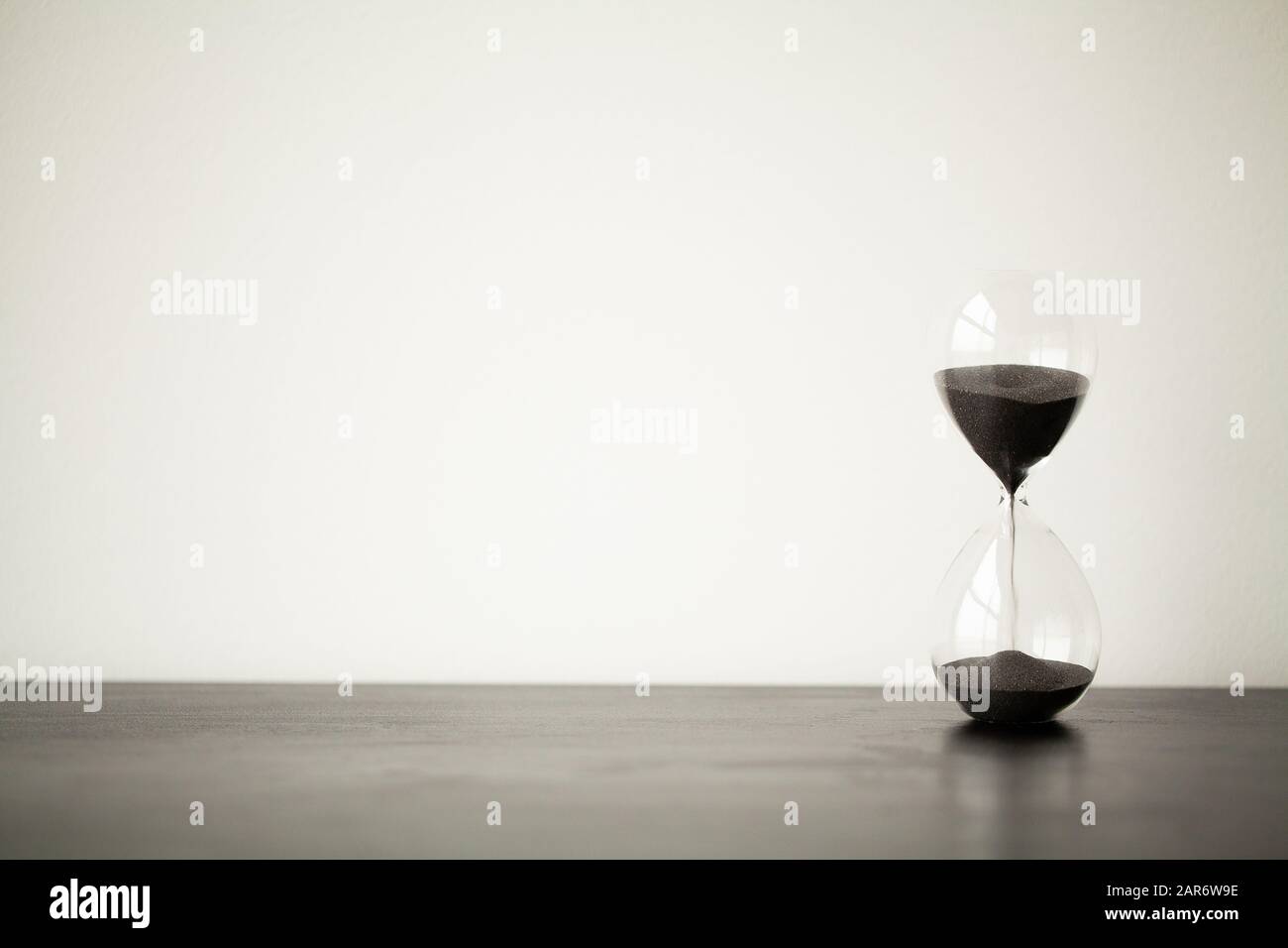 Time passing. A side view of an hourglass with falling sand Stock Photo ...
