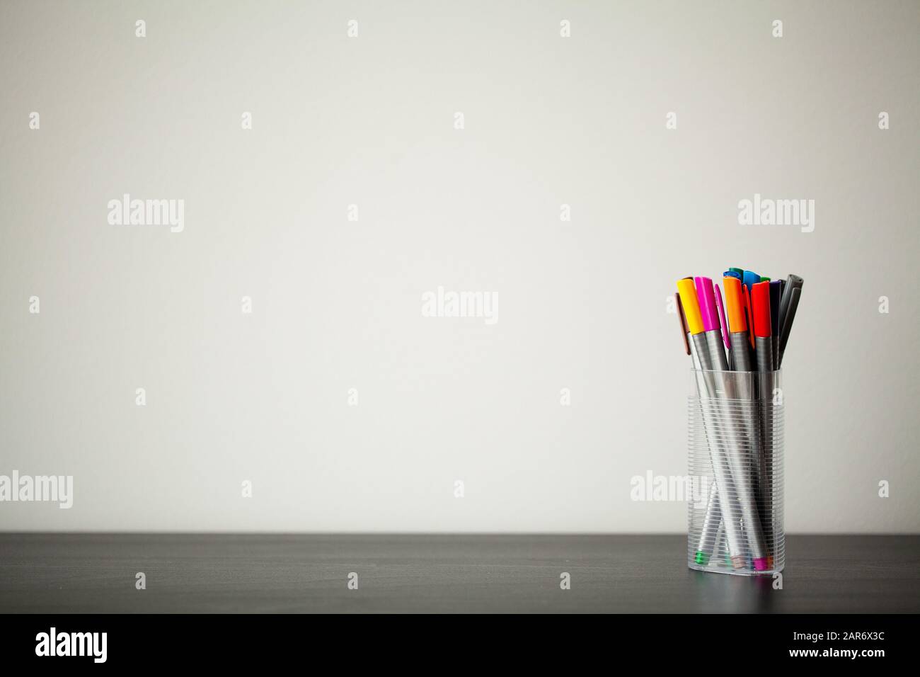 Set of markers in a plastic cup on wood table Stock Photo - Alamy