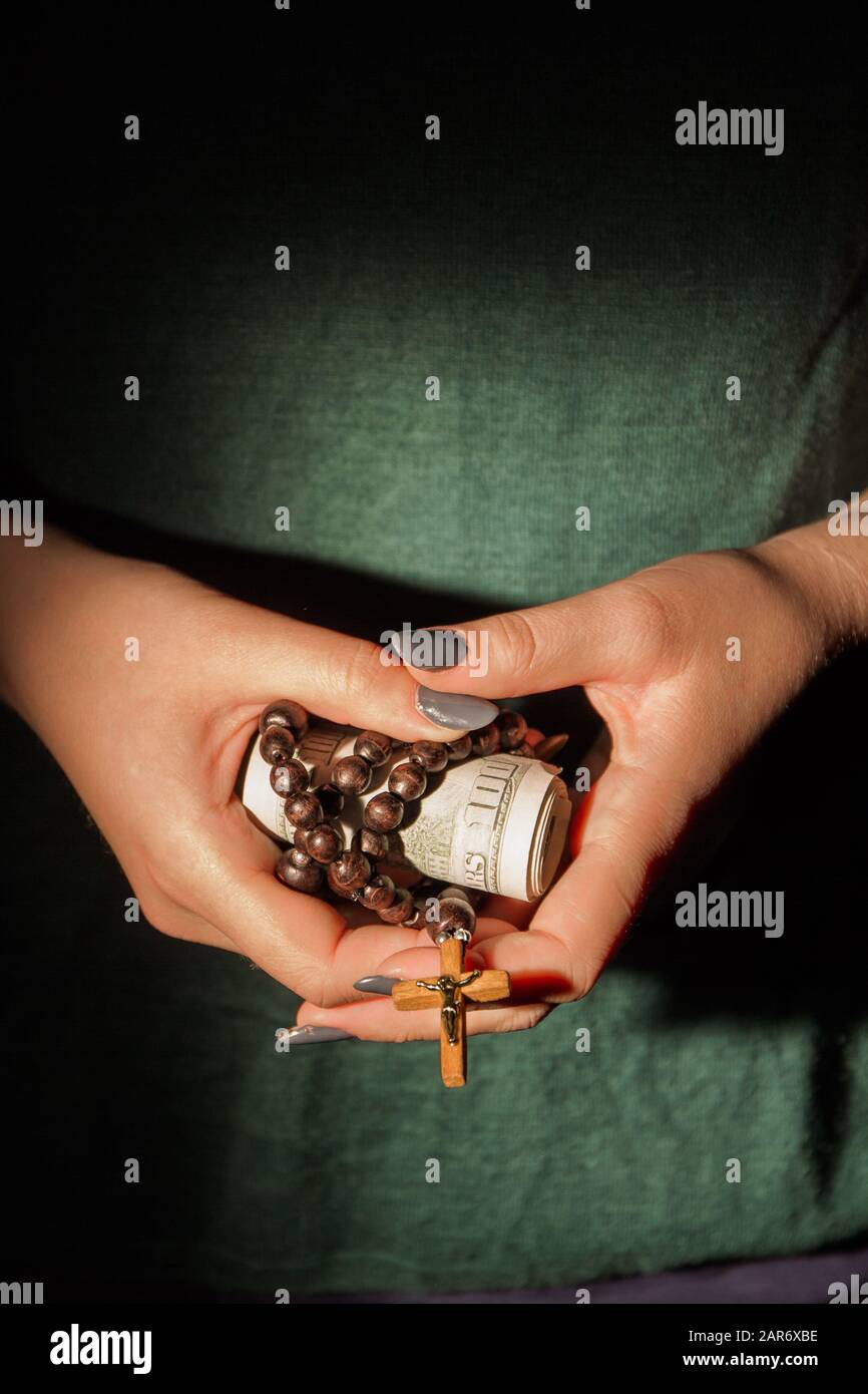 Roll of money dollars and rosary necklace with wooden cross Stock Photo ...