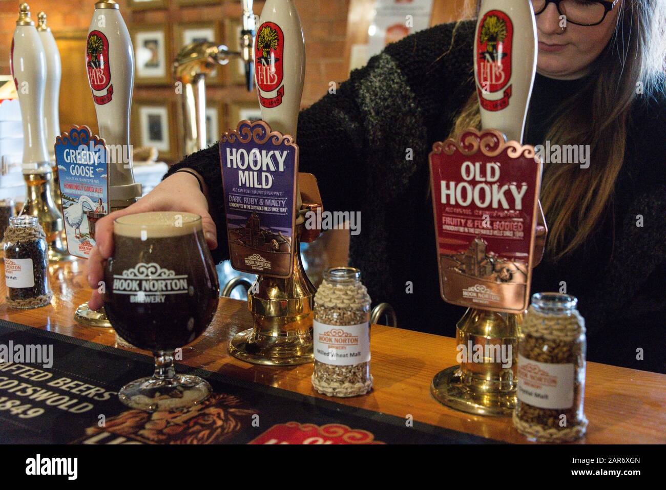A half pint of beer against a line up of beer pumps at an English pub ...