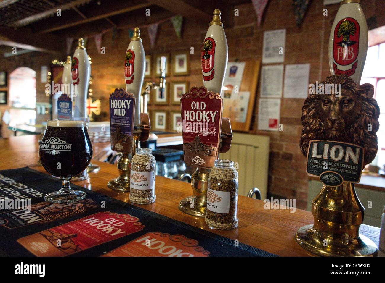 A half pint of beer against a line up of beer pumps at an English pub ...