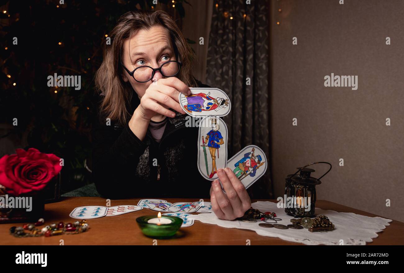 Mature woman fortuneteller holds a fortune-telling cards and show them ...