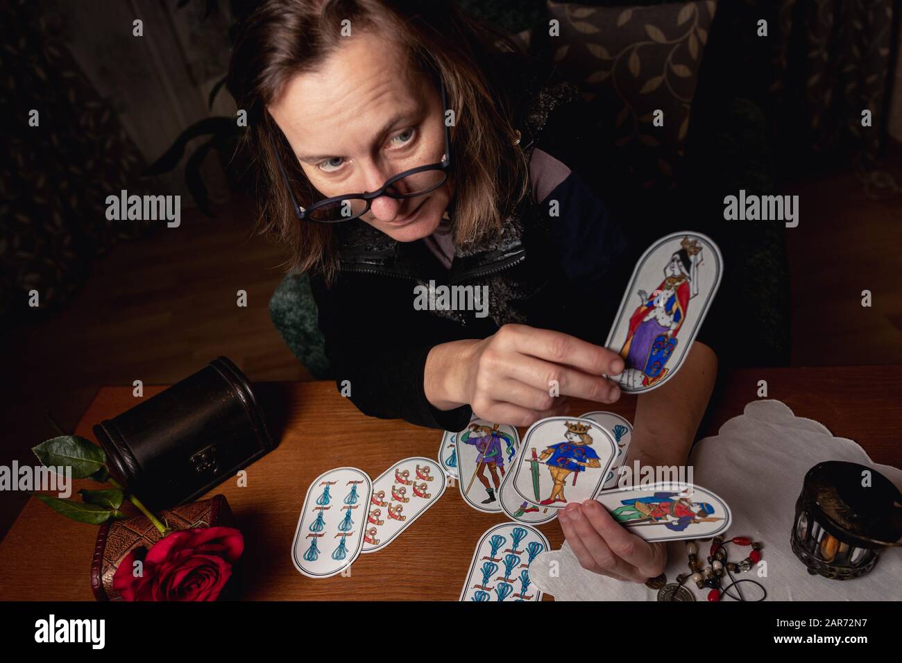 Mature woman is guessing on the cards. The fortuneteller holds a ...