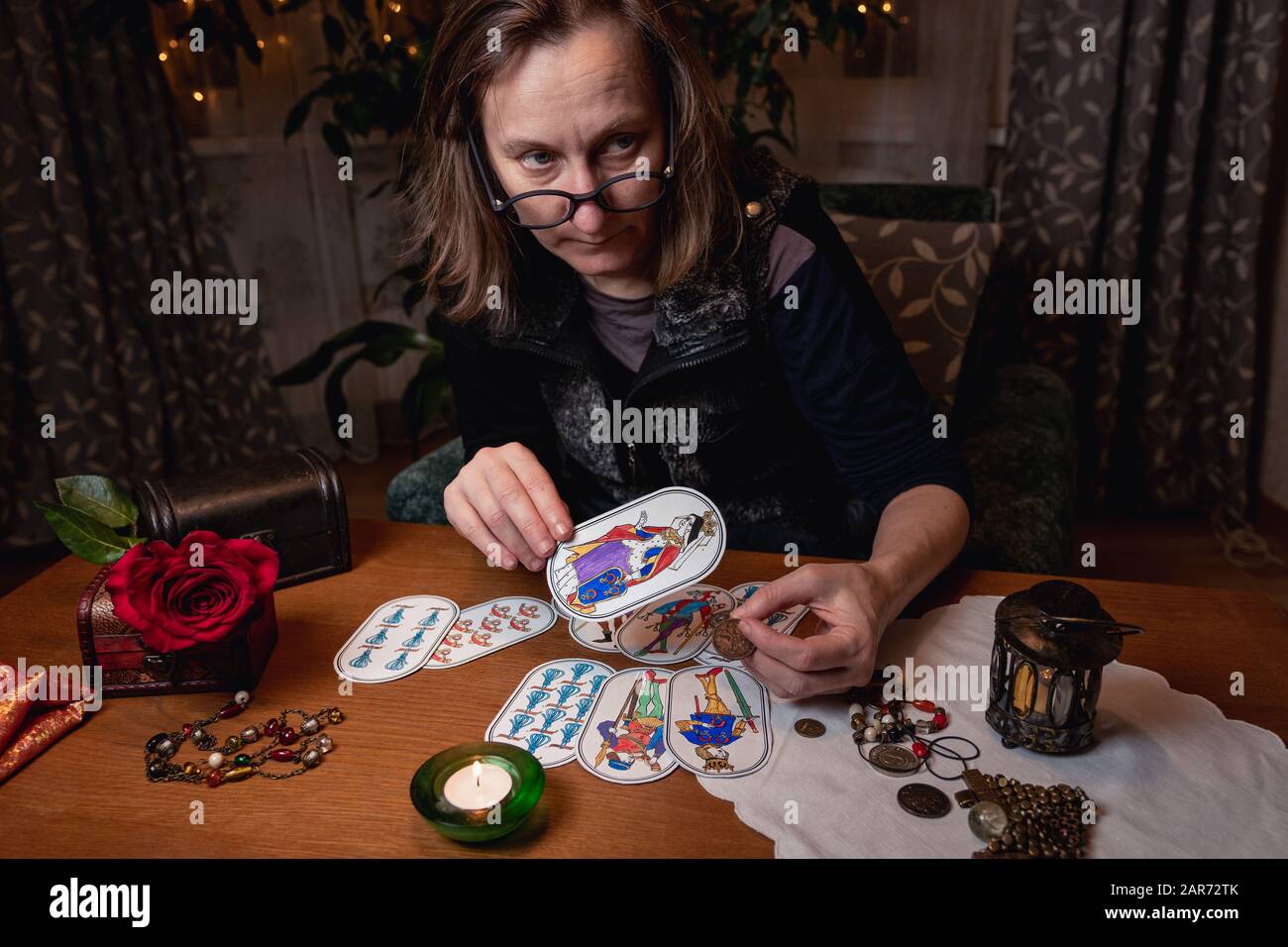 Mature woman is guessing on the cards. The fortuneteller holds a ...
