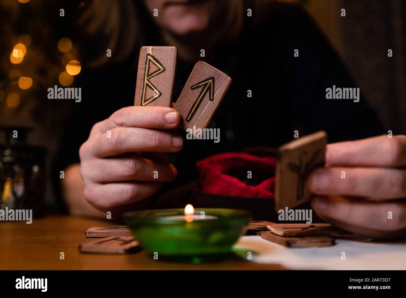 Portrait of a mature woman with runes. Woman holds in her hand runes ...