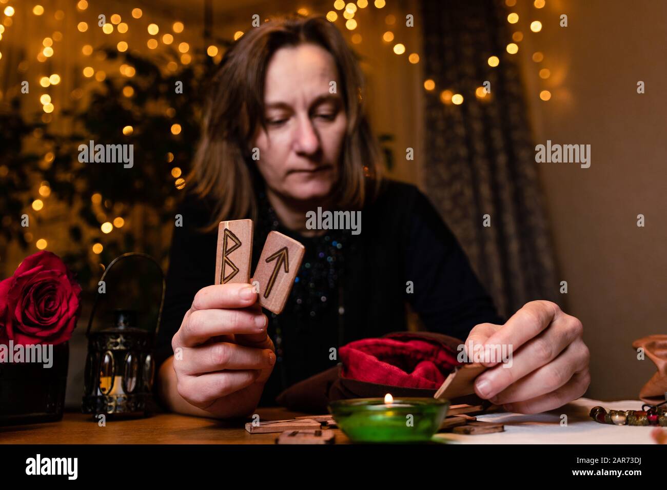 Portrait of a mature woman with runes. Woman holds in her hand runes ...