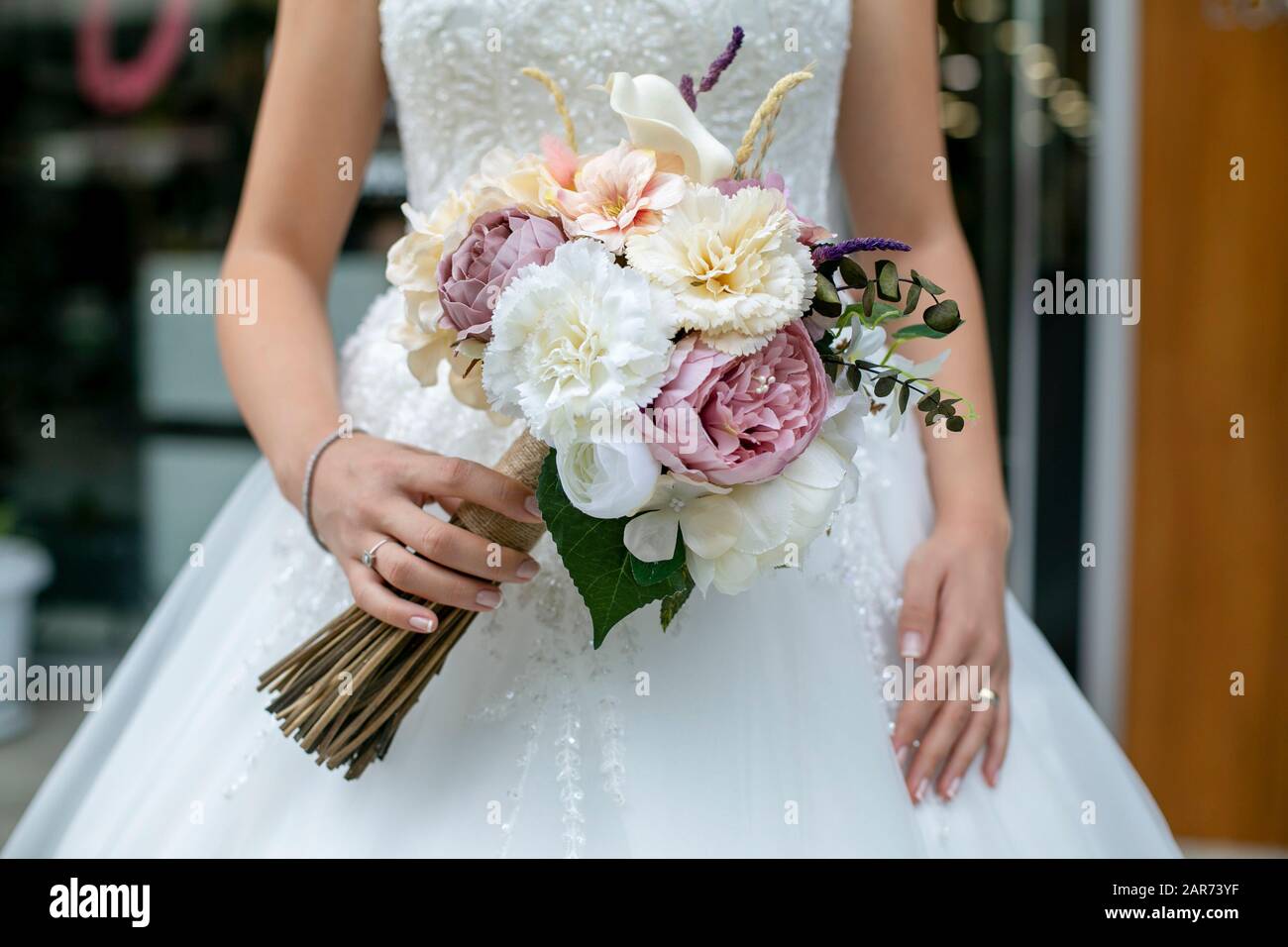the bride in white dress and a bunch of flowers in her hand Stock Photo ...