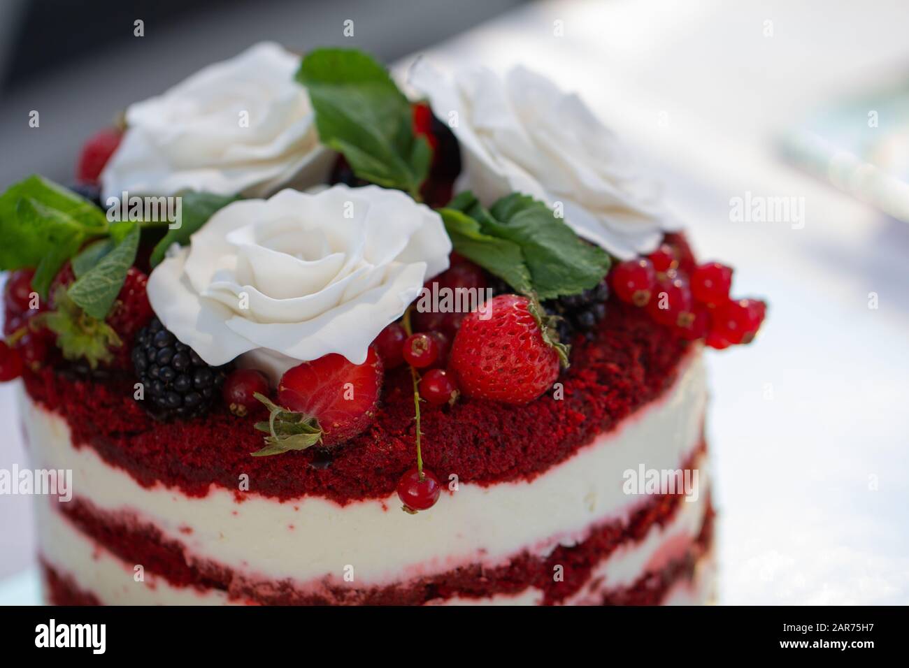 Red velvet cake with close up with white roses Stock Photo - Alamy