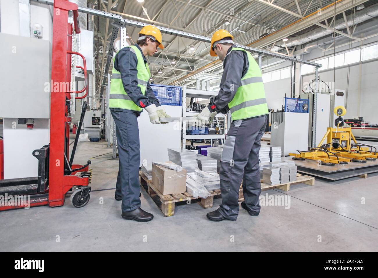 Two workers carry aluminium billet at CNC machine shop Stock Photo - Alamy