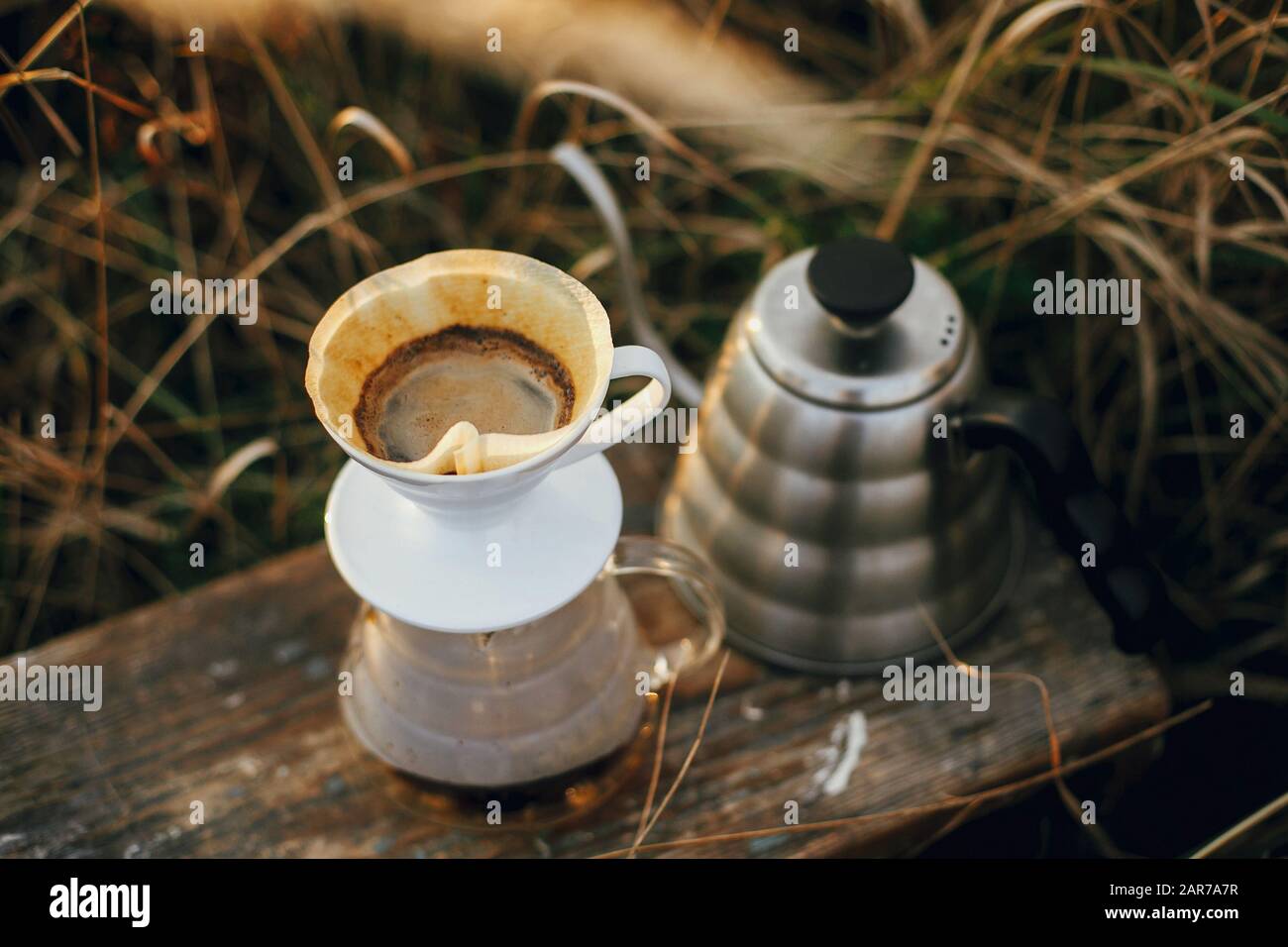 Alternative coffee brewing outdoors. Atmospheric rustic moment. Pouring ...
