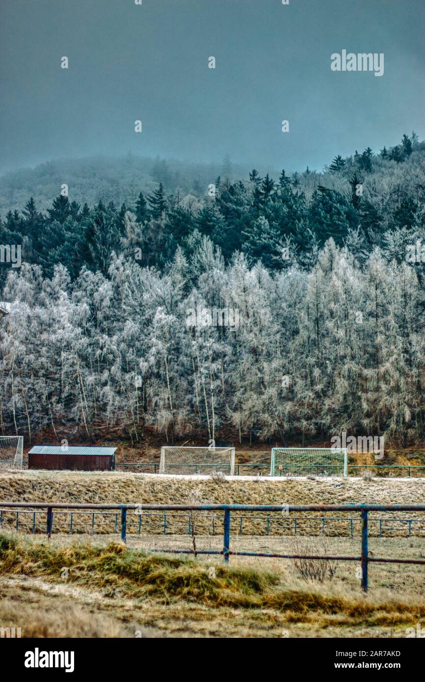 winter football field with frosted mountains in background and goals ...