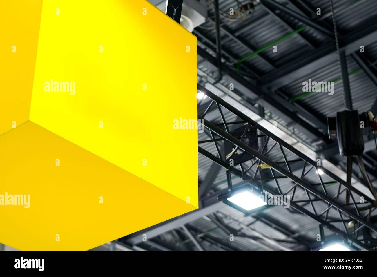 Part of a large luminous yellow cube hanging under the ceiling of a ...