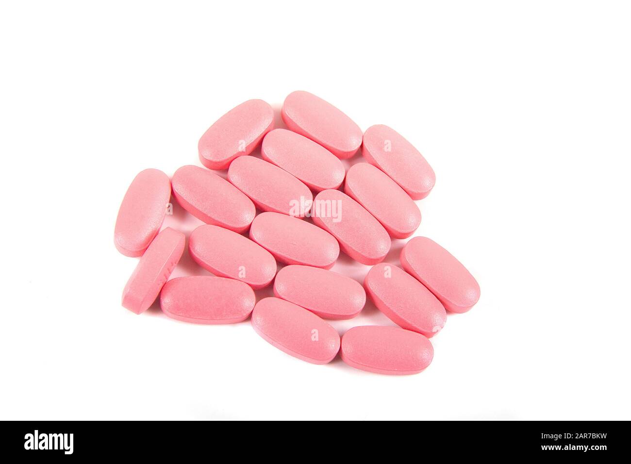 Pink tablets or medicine on a white background Stock Photo - Alamy