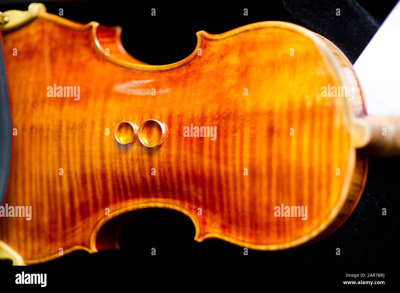 wedding rings lie on the back deck of the violin. top view Stock Photo ...