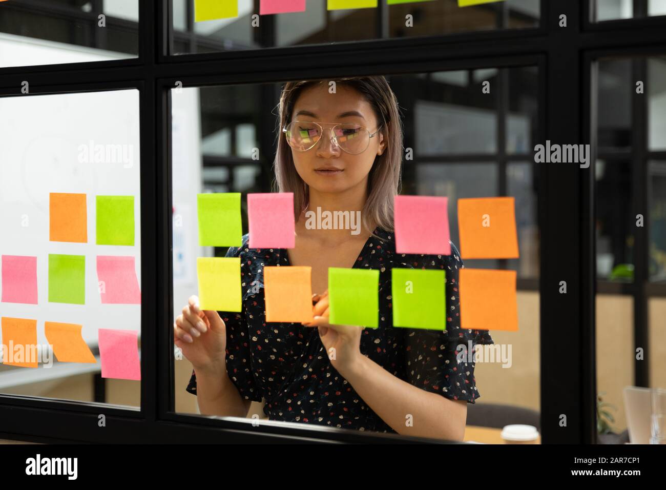 Asian female employee work on plan posting sticky notes Stock Photo - Alamy