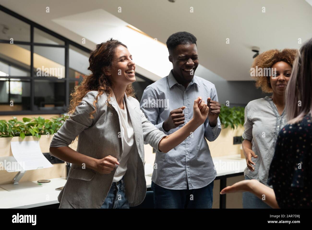 Overjoyed multiethnic colleagues have fun dancing in office Stock Photo ...