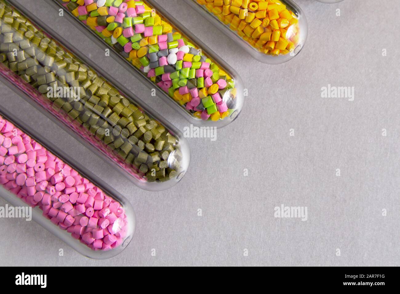 Plastic pellets .Polymeric dye in test tubes on gray background Stock ...