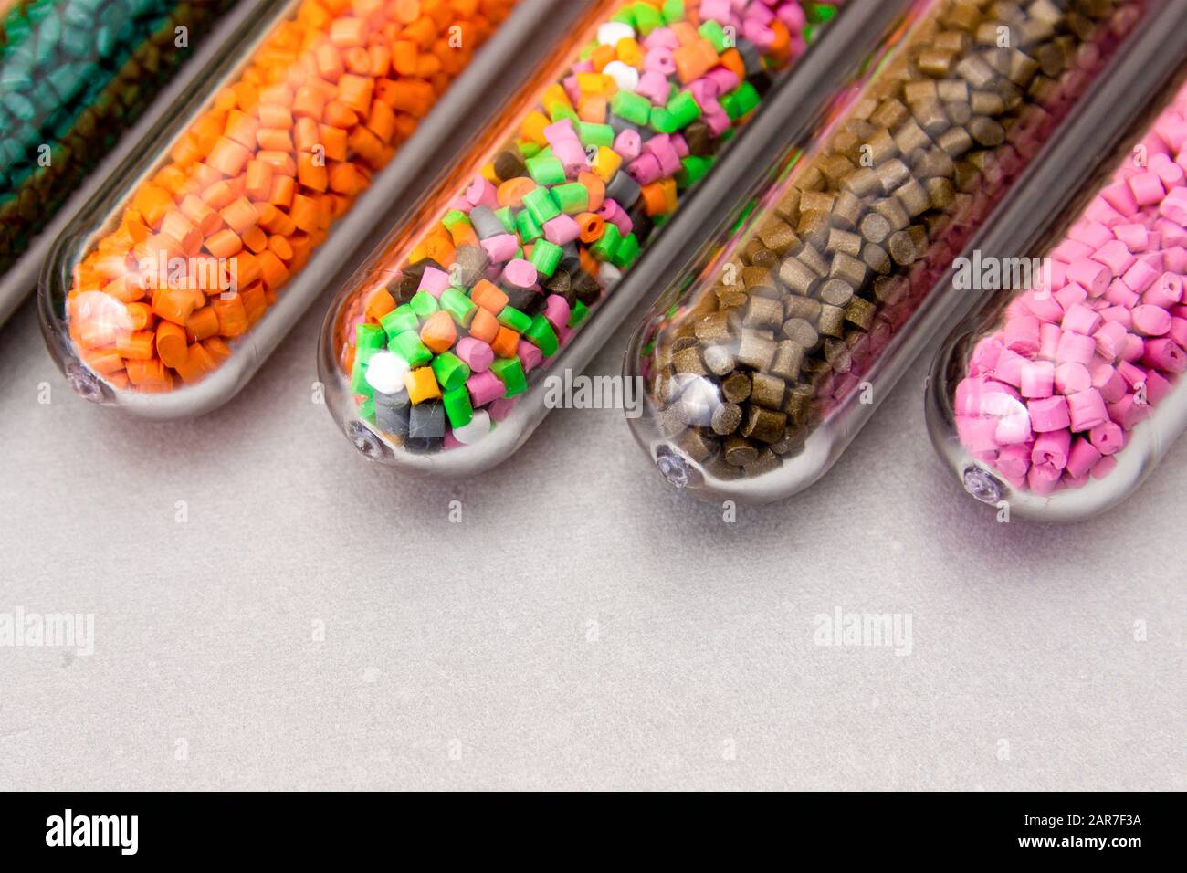 Plastic pellets .Polymeric dye in test tubes on gray background Stock ...