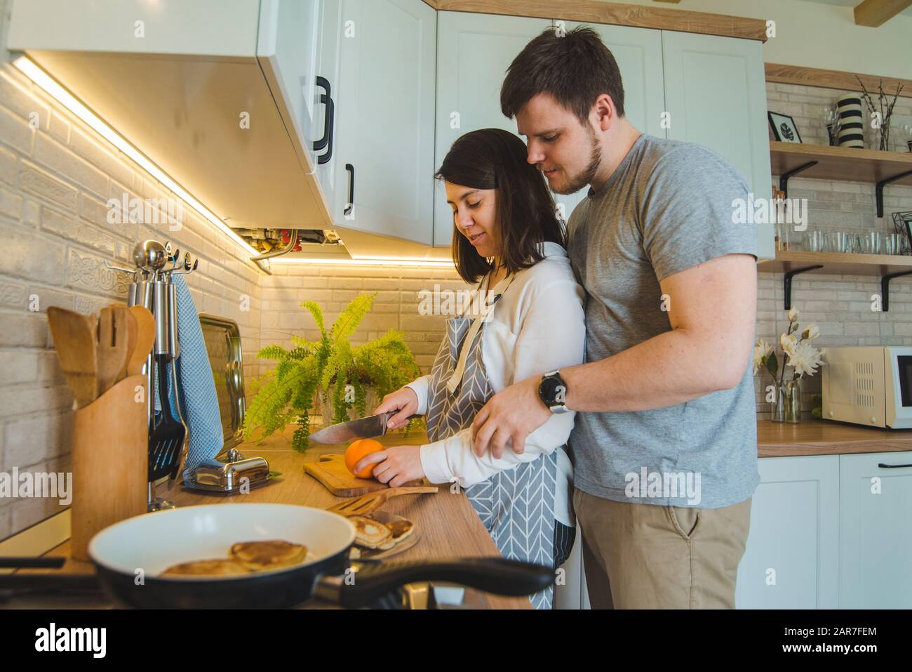 lovely couple hugging on the kitchen while cooking breakfast Stock ...