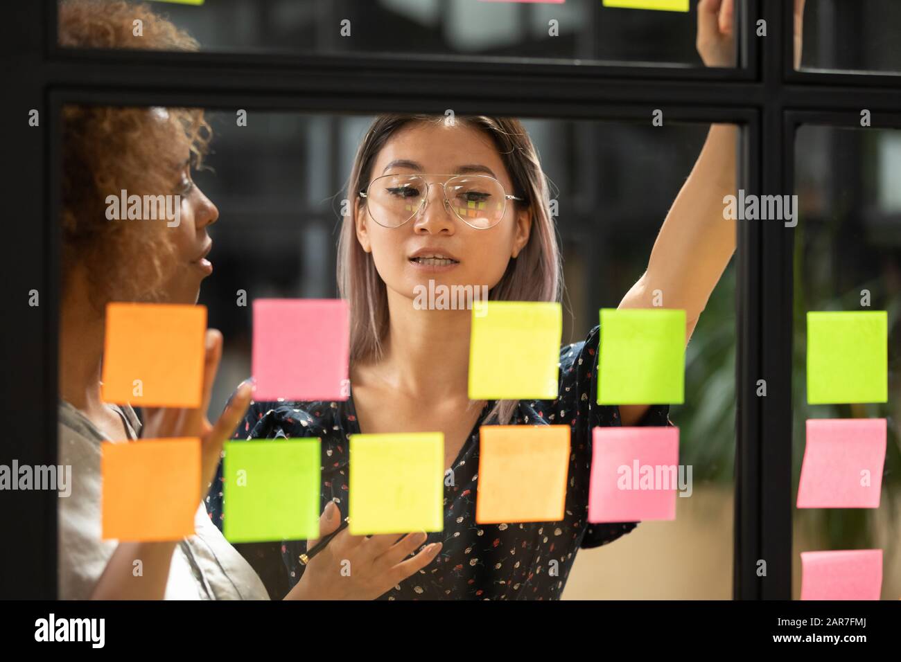 Asian female employee work with sticky notes in office Stock Photo - Alamy