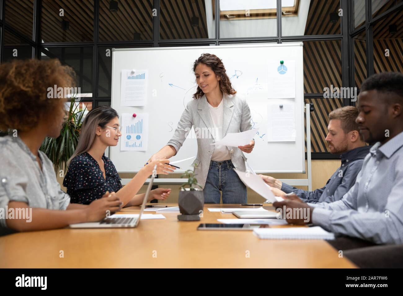 Female coach share handouts to listeners at meeting Stock Photo - Alamy