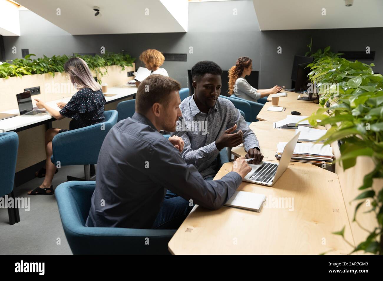 Diverse employees busy cooperating in shared office Stock Photo - Alamy