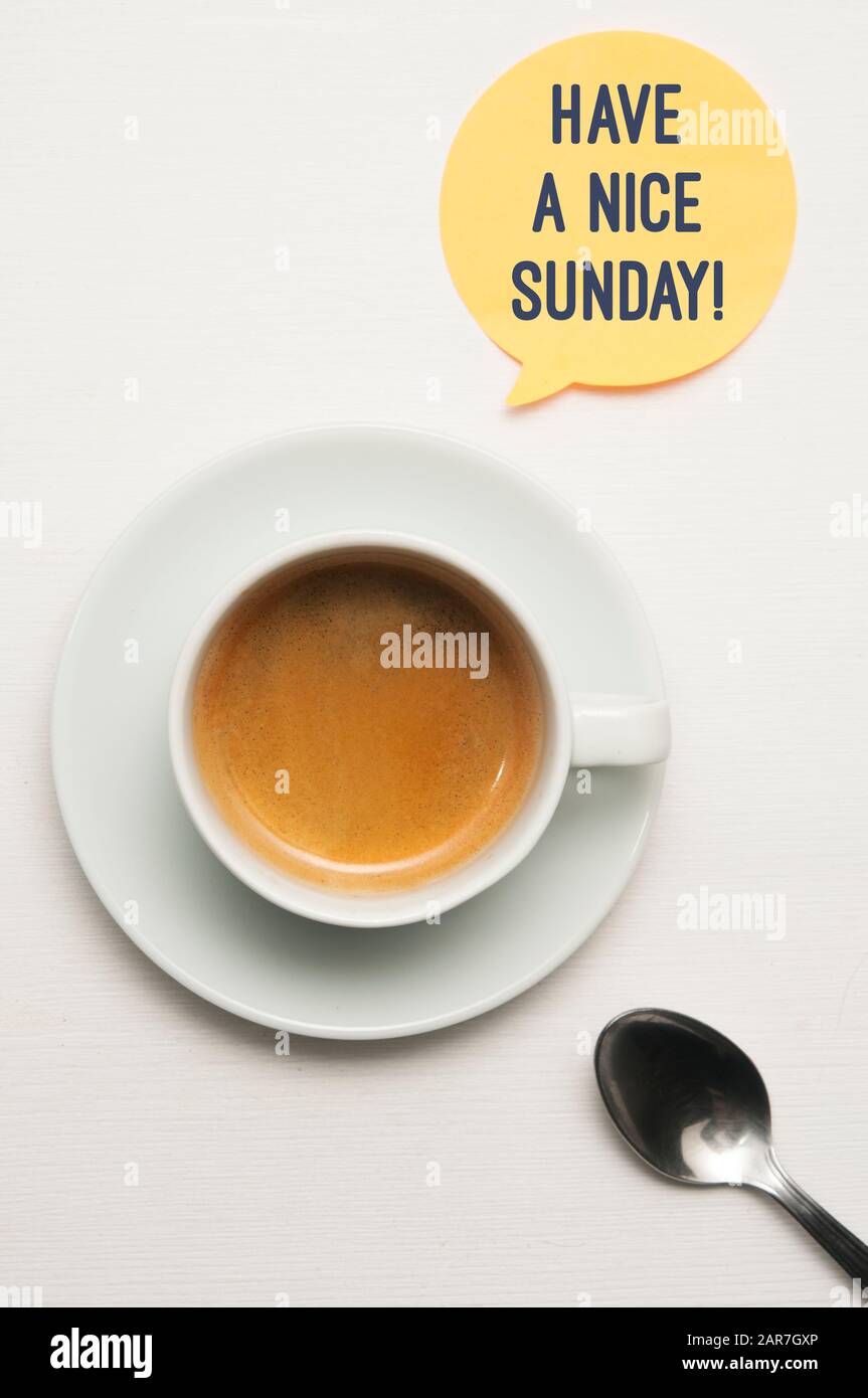 Have a nice sunday concept: a cup of coffee on a white wooden table and ...