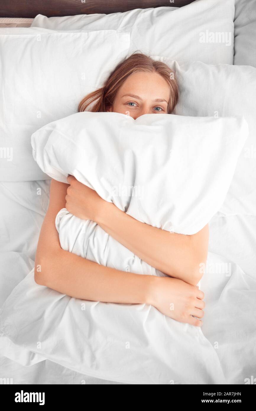Morning At Home Woman Lying On Bed Hugging Pillow Smiling Playful Top