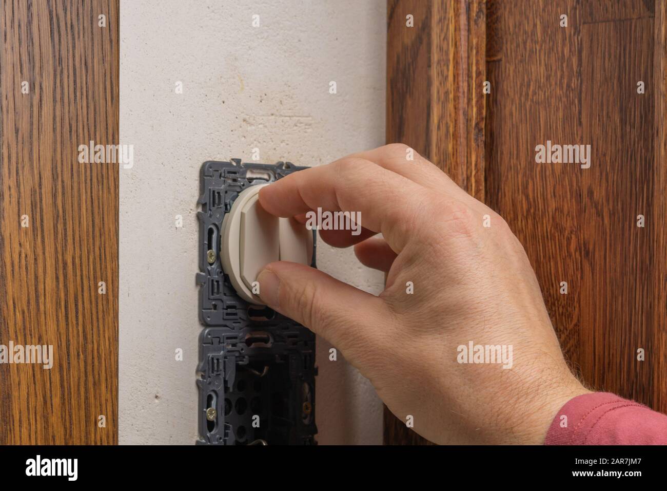 A master electrician mounts an electrical plug on a wall. Vintage ...