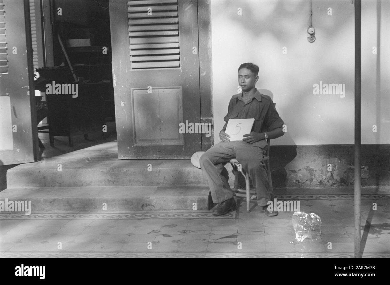 Portrait photo KNIL militarily. He carries on his lap a sign with the ...