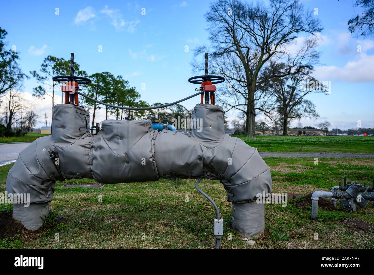 Insulated and heat traced water main pipe chained open Stock Photo - Alamy