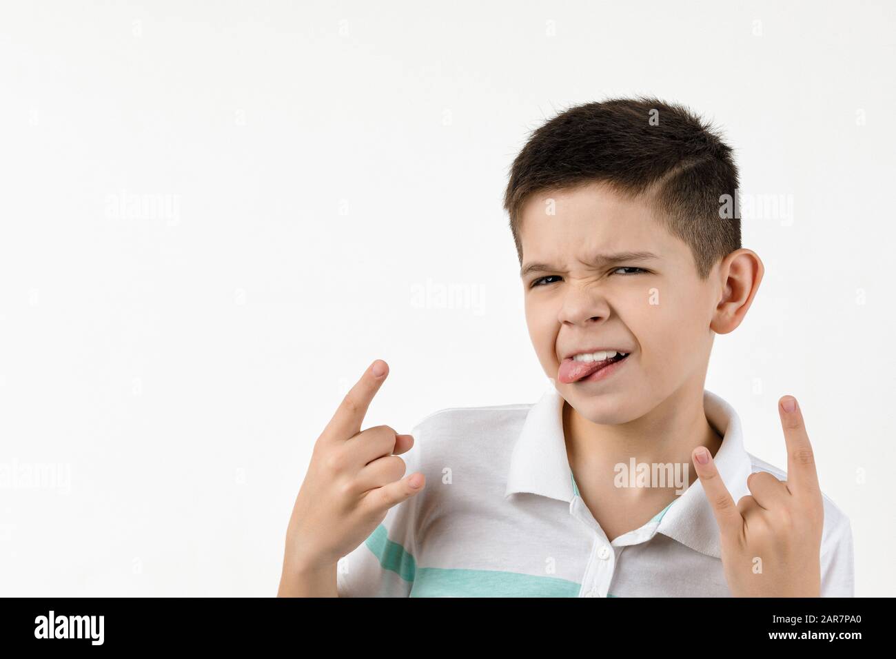 Cute little child boy in striped t-shirt making Rock gesture on white ...