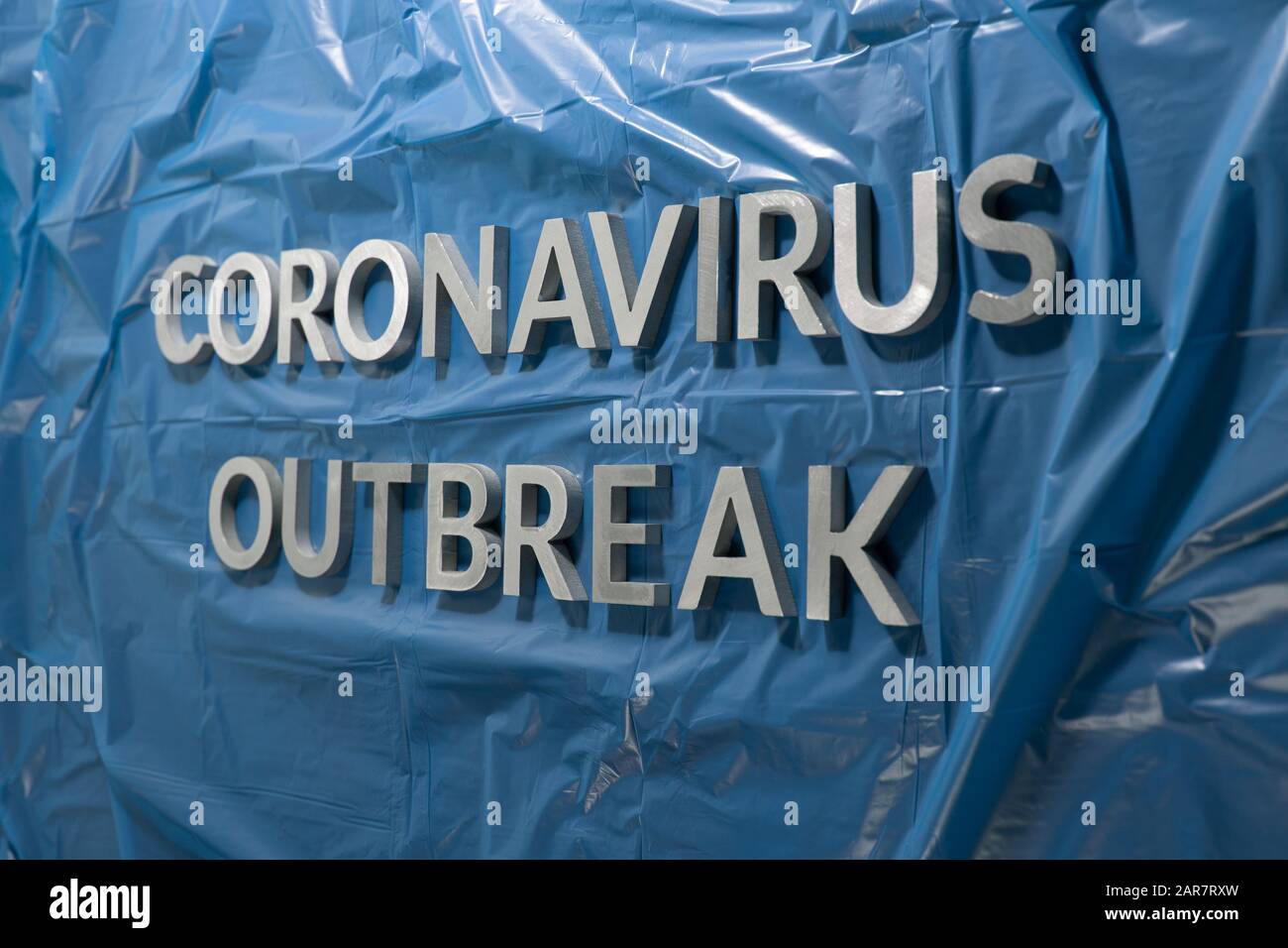 The words coronavirus outbreak laid with silver metal letters on ...