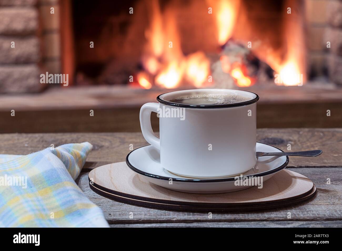Cozy scene before fireplace with a cup of tea, in country house, winter ...