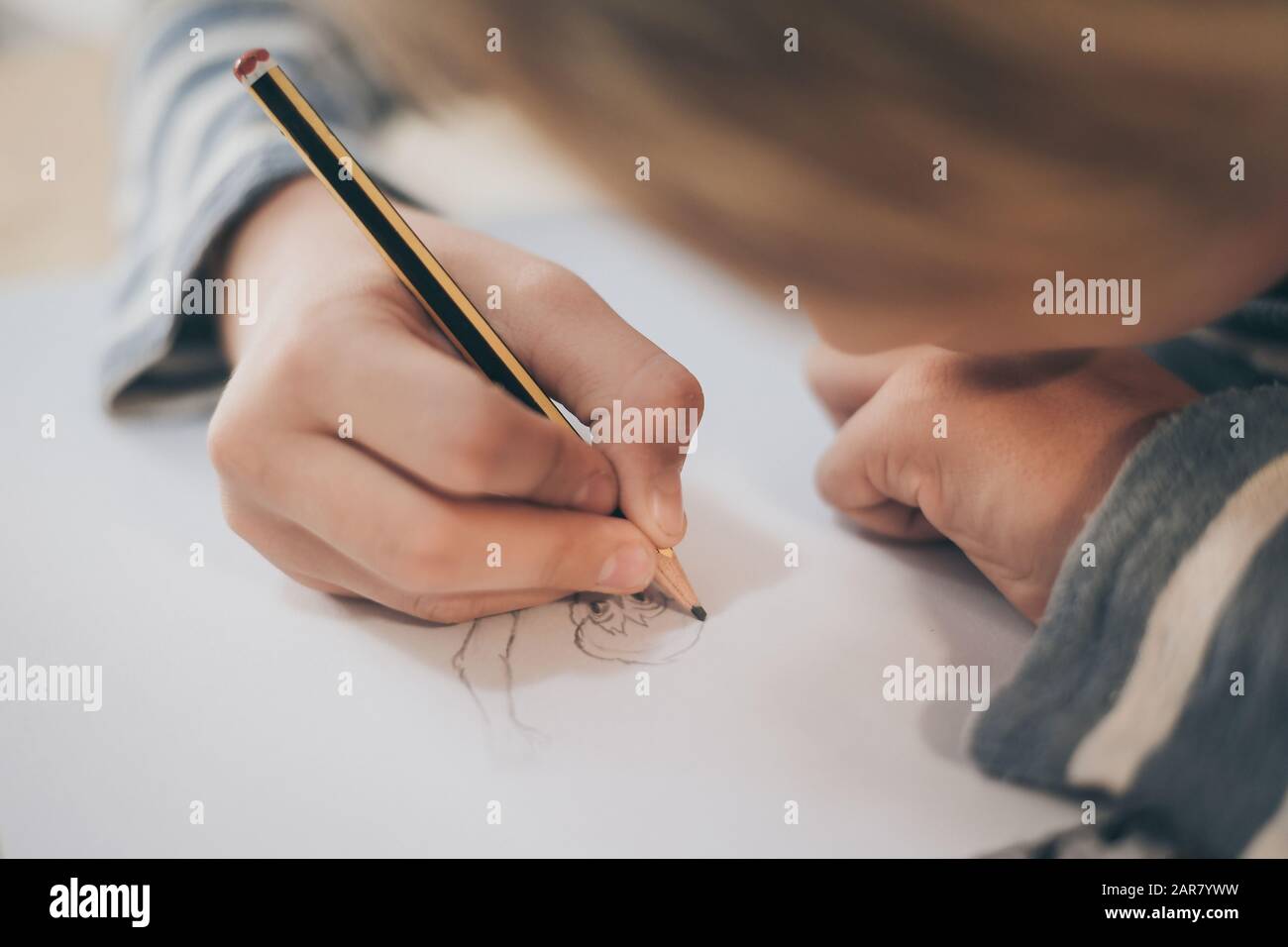 Close up view of student drawing with pencil. Boy doing homework ...