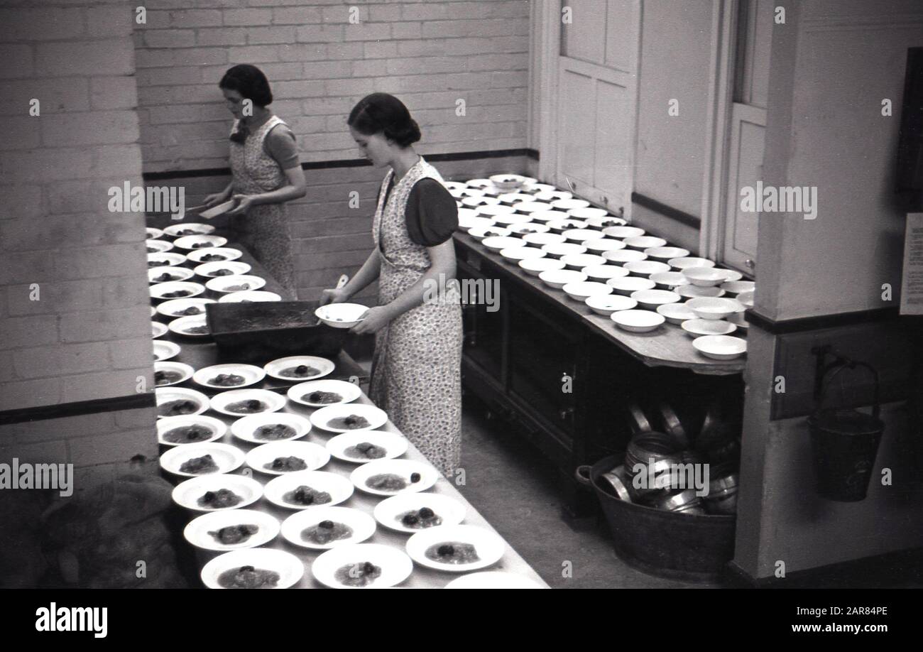 1948, historical, post-war and two female cooks in aprons in a factory ...