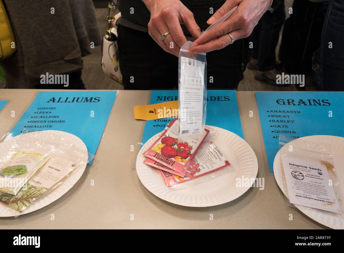 People select seeds to take home at the opening of the seed sharing ...