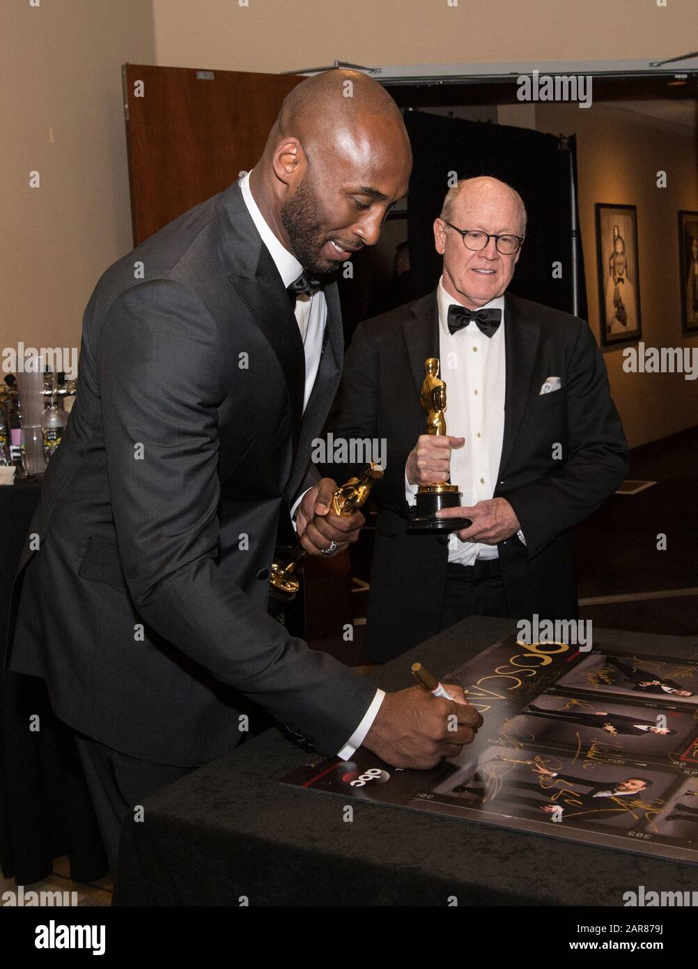 Kobe Bryant signs posters backstage with the Oscar® for best animated ...