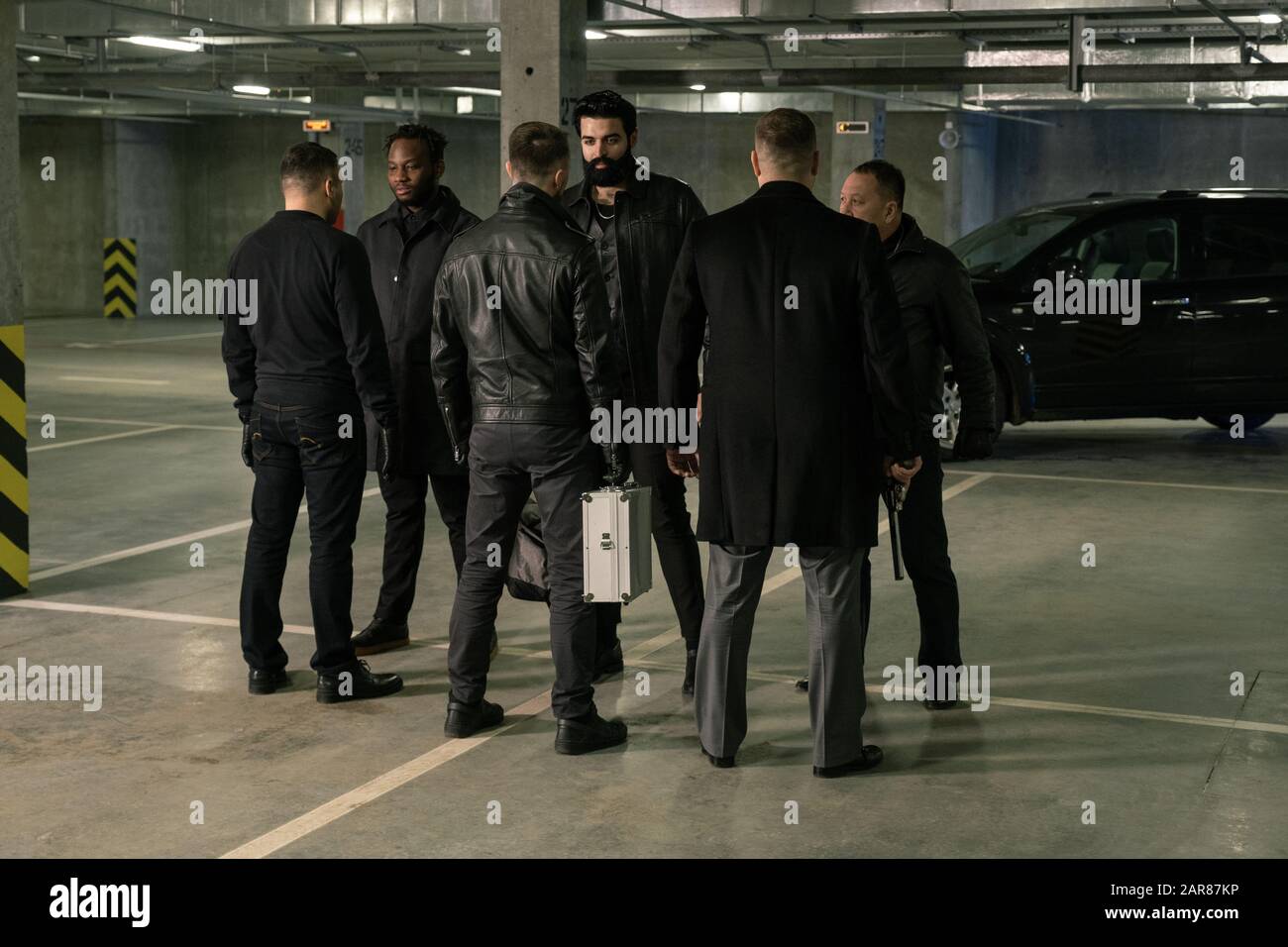 Group of six intercultrual men in black standing in front of each other ...