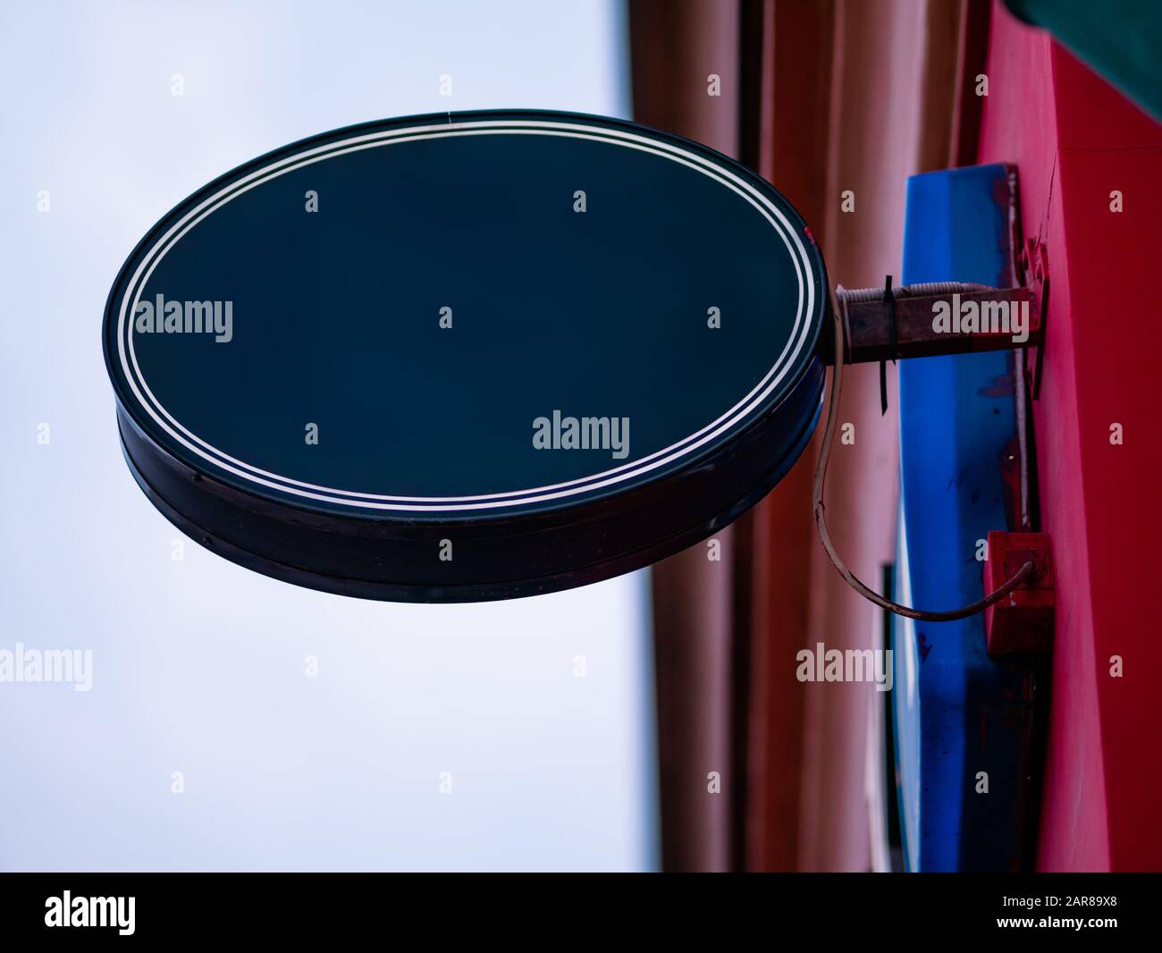 Oval real sign on wall of building. Dark blue rounded signboard of cafe ...