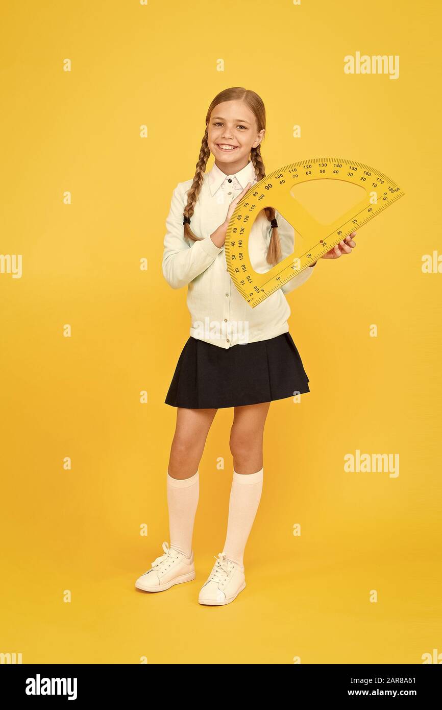 Being ready for lesson. Cute schoolgirl holding protractor for lesson ...