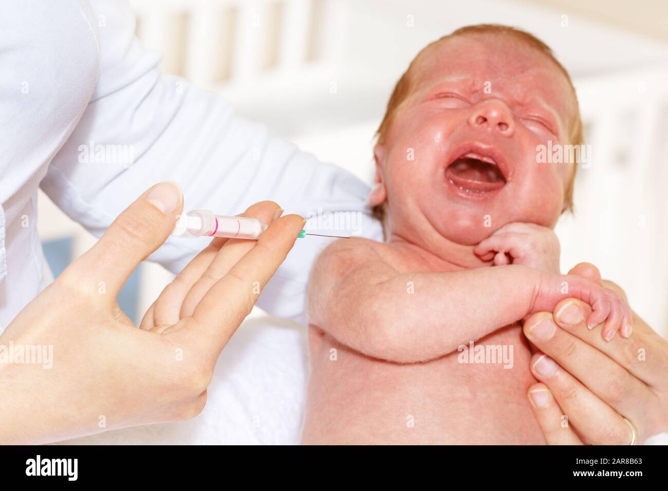 Baby infant boy cry during vaccination with nurse hold syringe near arm ...