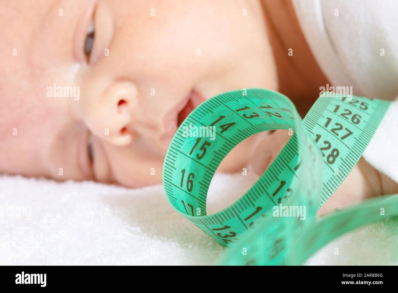 Little baby infant boy head with green centimeter on foreground Stock ...