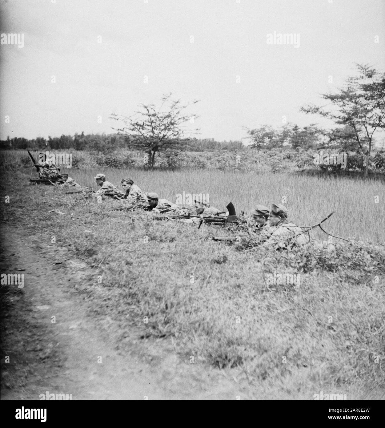 Soldiers in position behind dike of rice field Date: 1947/01/01 ...