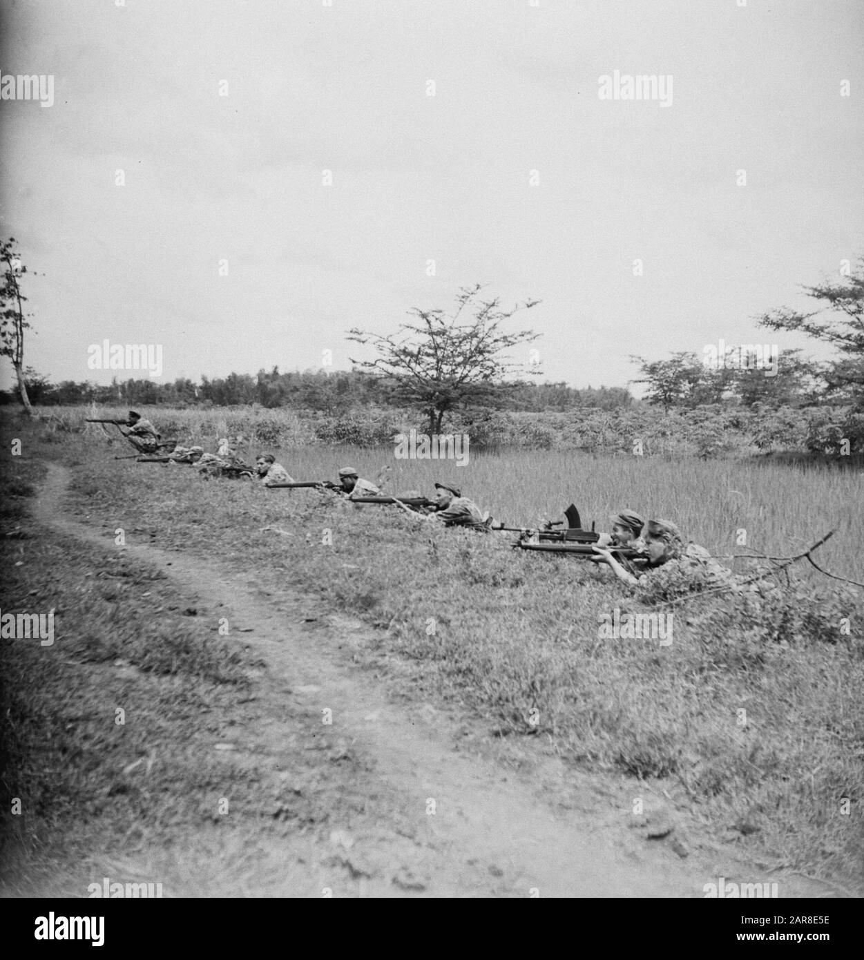Soldiers in position behind dike of rice field Date: 1947/01/01 ...