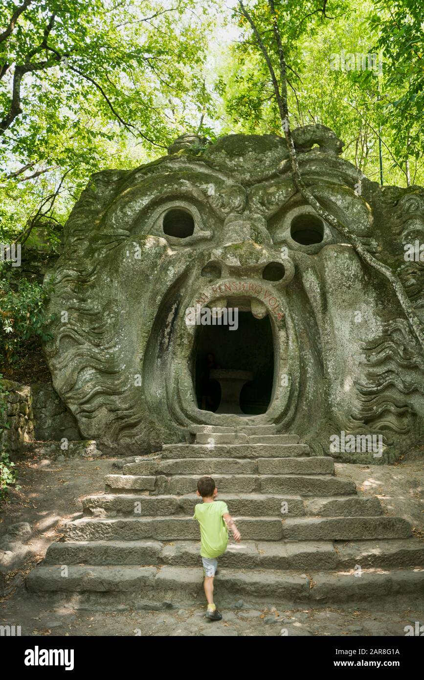 Young boy walks up the stone stairs toward the giant mouth of a ...