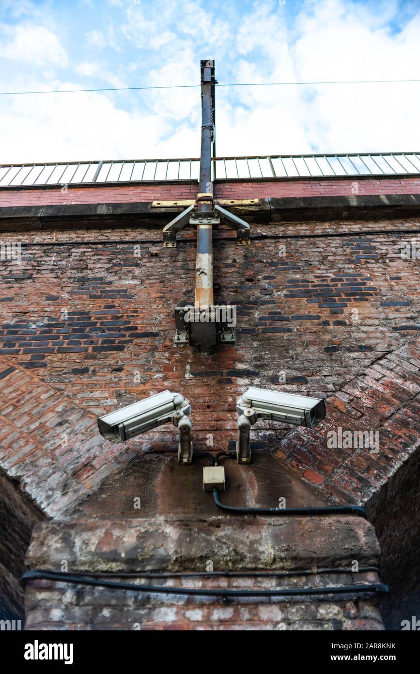 CCTV camera urban red brick wall overpass train tracks manchester ...